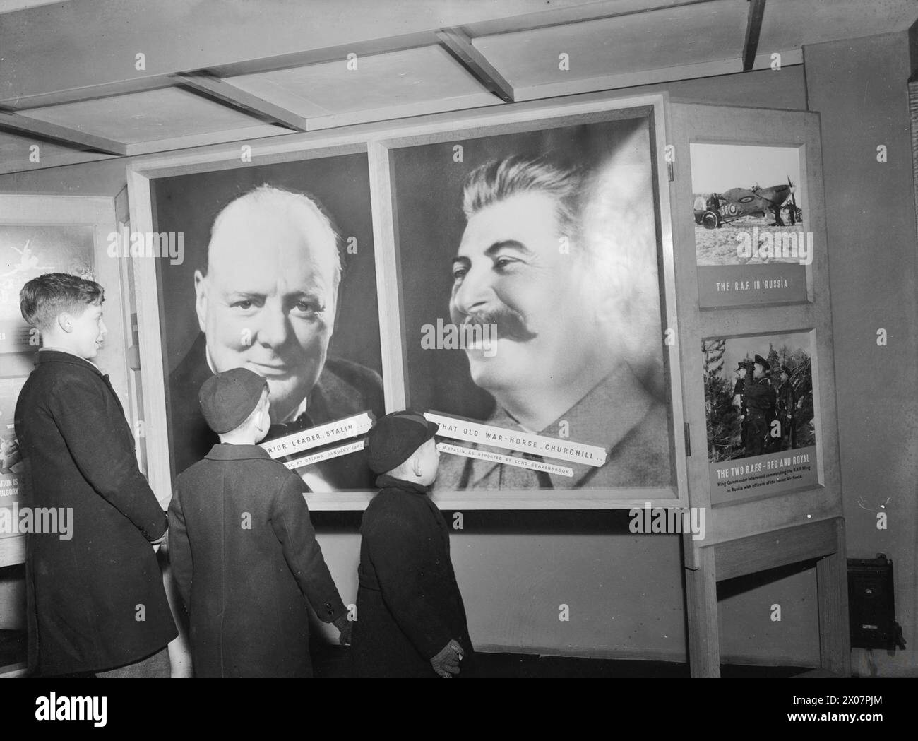 Three boys view photographs of Winston Churchill and Joseph Stalin at ...