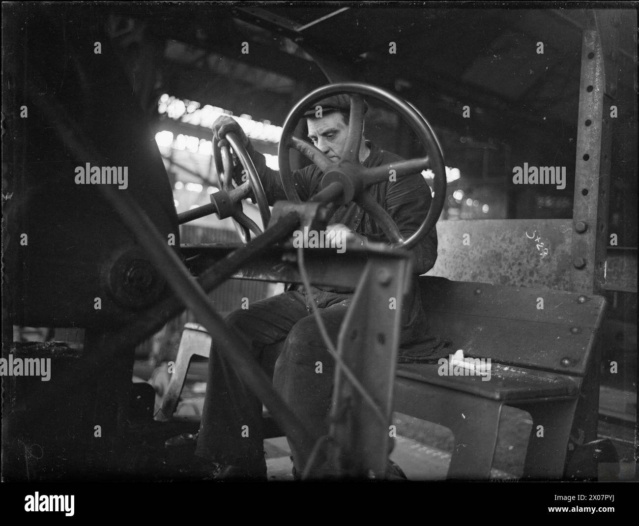 A worker operates a punching machine during the construction of ...