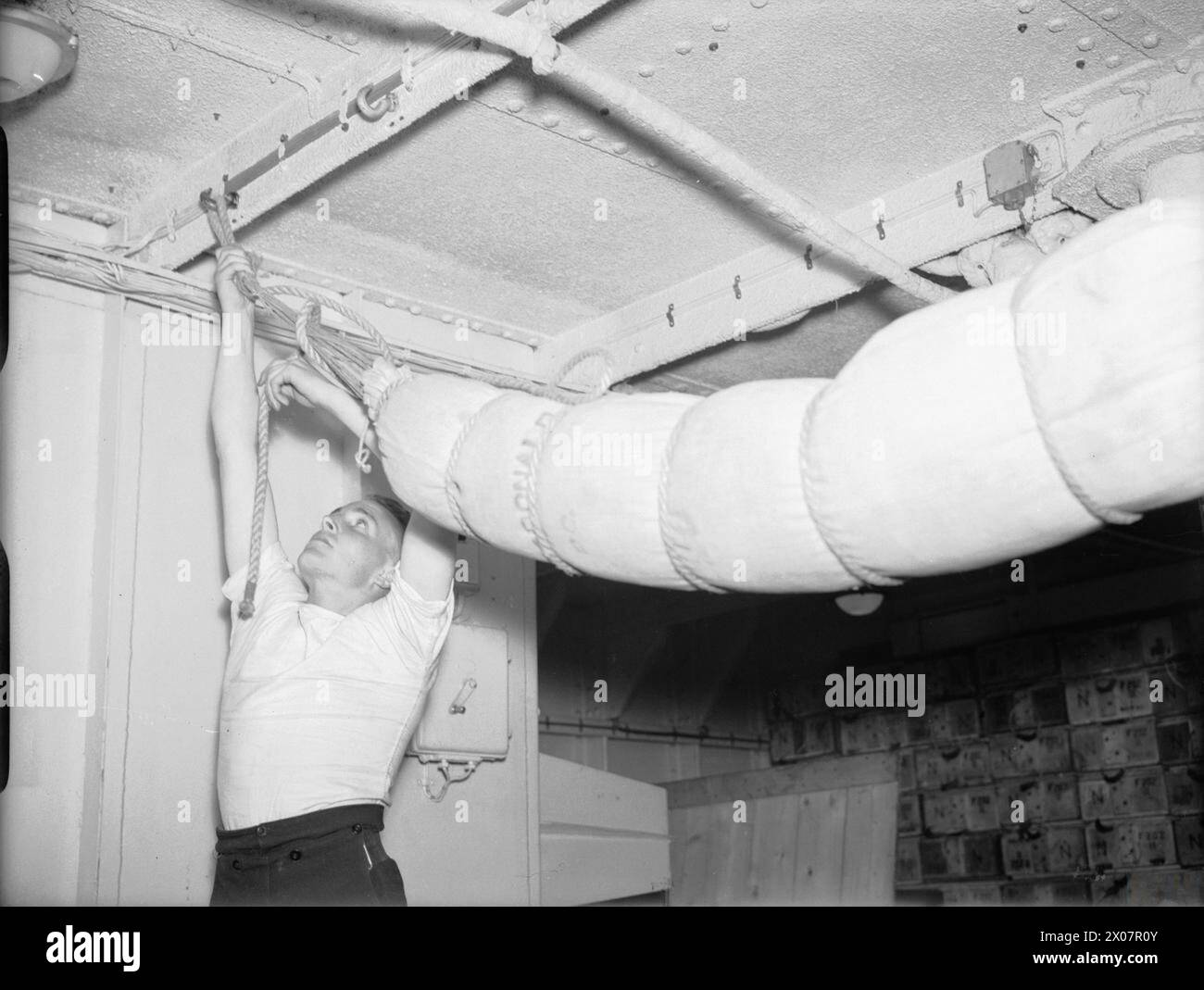 THE ROYAL NAVY DURING THE SECOND WORLD WAR - A sailor secures a rolled ...