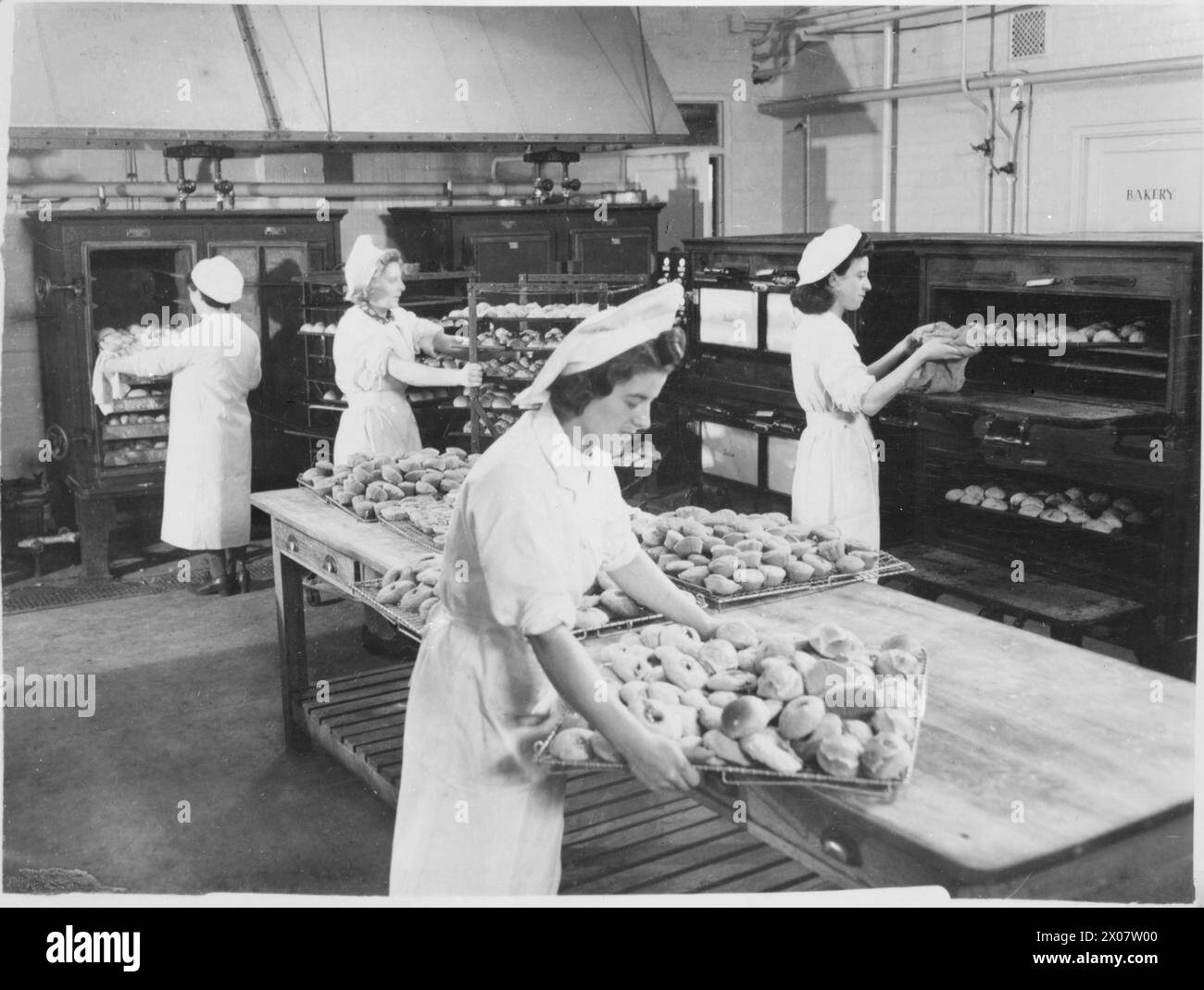 FACTORY CANTEEN KITCHENS, UK, 1942 - Cooks prepare trays of pastries ...
