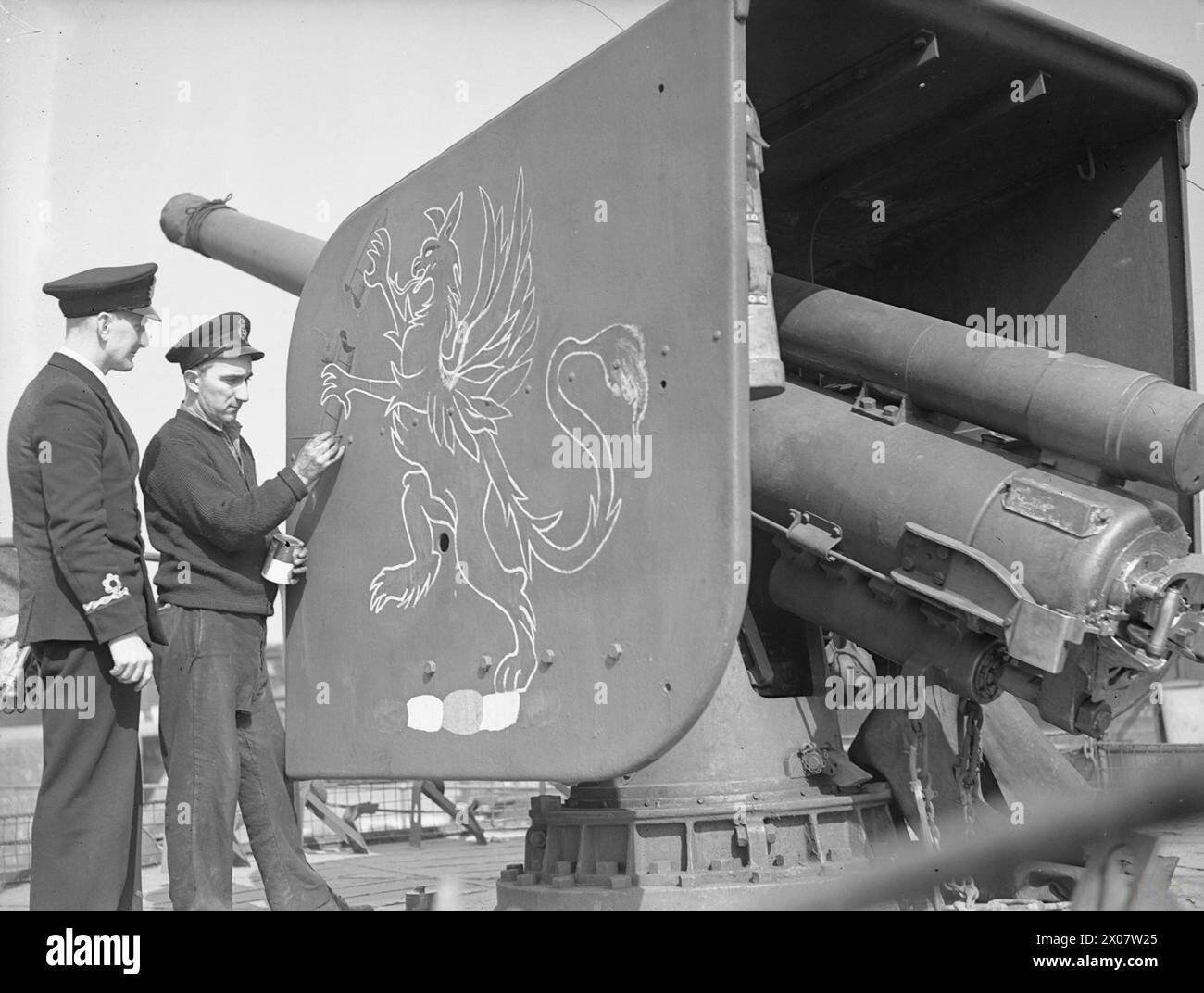 A Petty Officer applies finishing touches to the battle crest on HMS ...