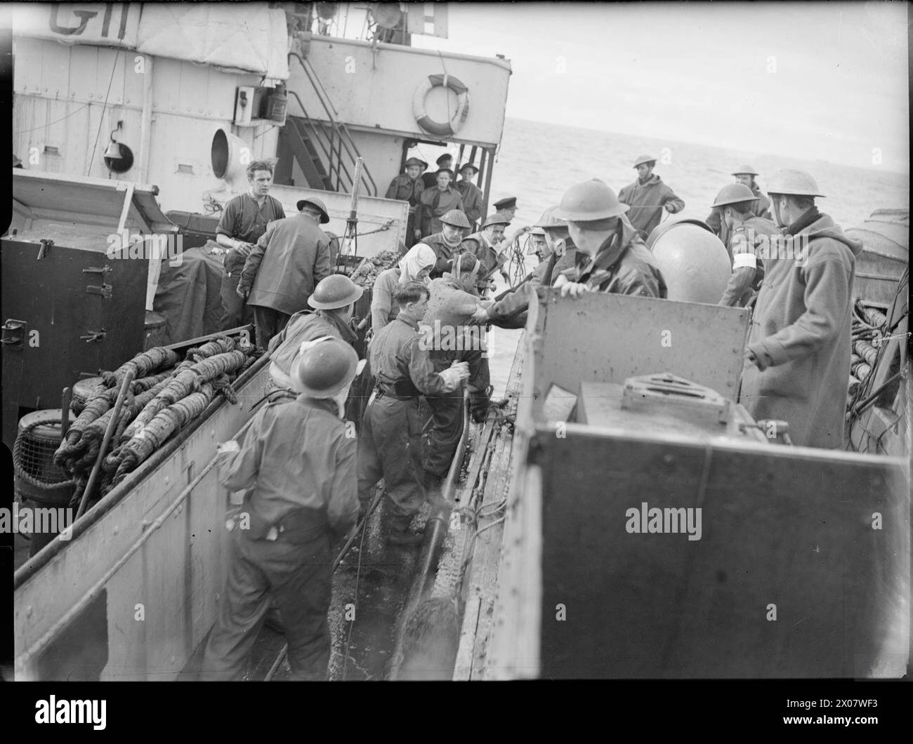 Wounded men are transferred from a landing craft to a hospital ship ...