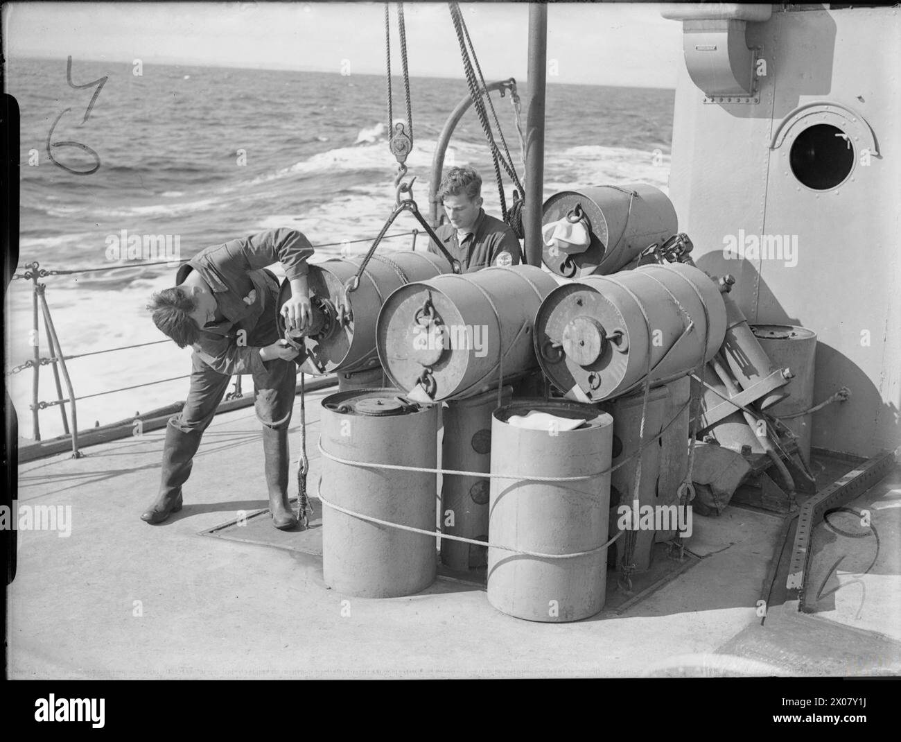 Torpedomen on HMS Javelin adjust depth settings on depth charges during ...