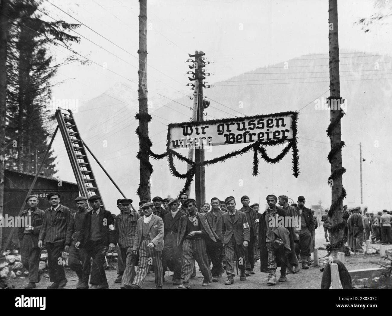 Liberated prisoners able to walk pass under a sign reading 'We Welcome ...
