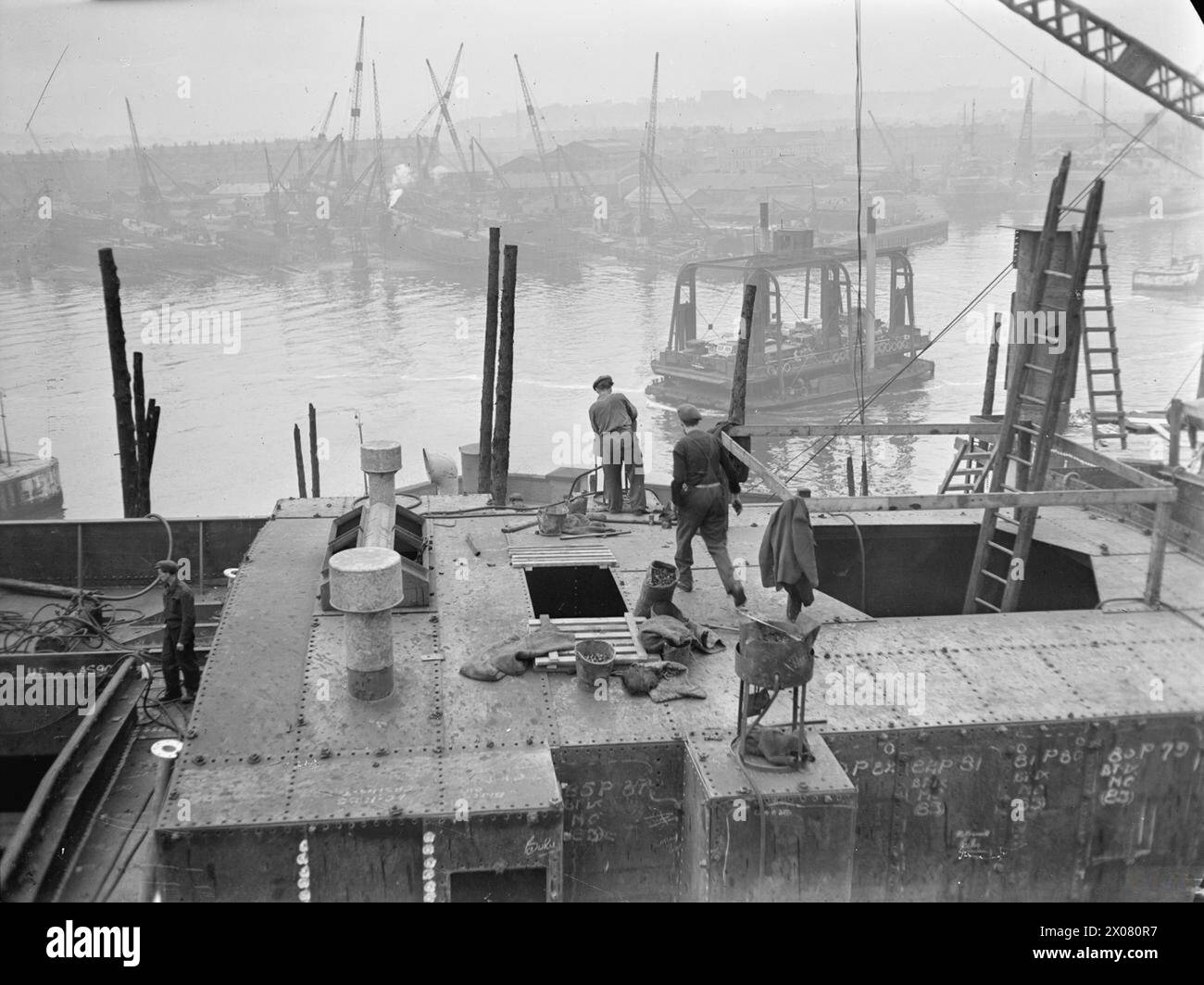 Workers build the deck superstructure of a merchant ship at Harland and ...