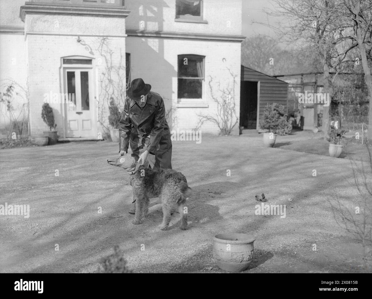 Circa 1940, Lieutenant Colonel E H Richardson fits a gas mask to an ...