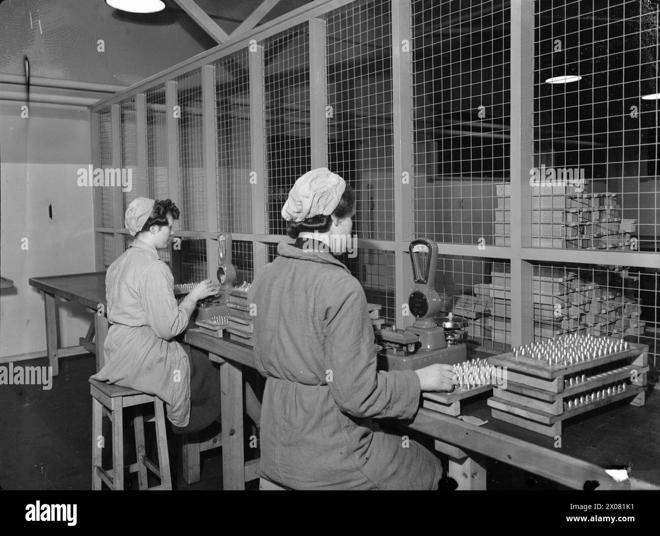 WAR INDUSTRY, UK, c 1942 - Female munitions workers weigh fuses at a ...