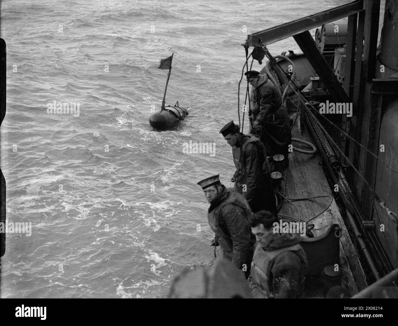 A minesweeping trawler of the Dover Command pays out sweep wire as the ...
