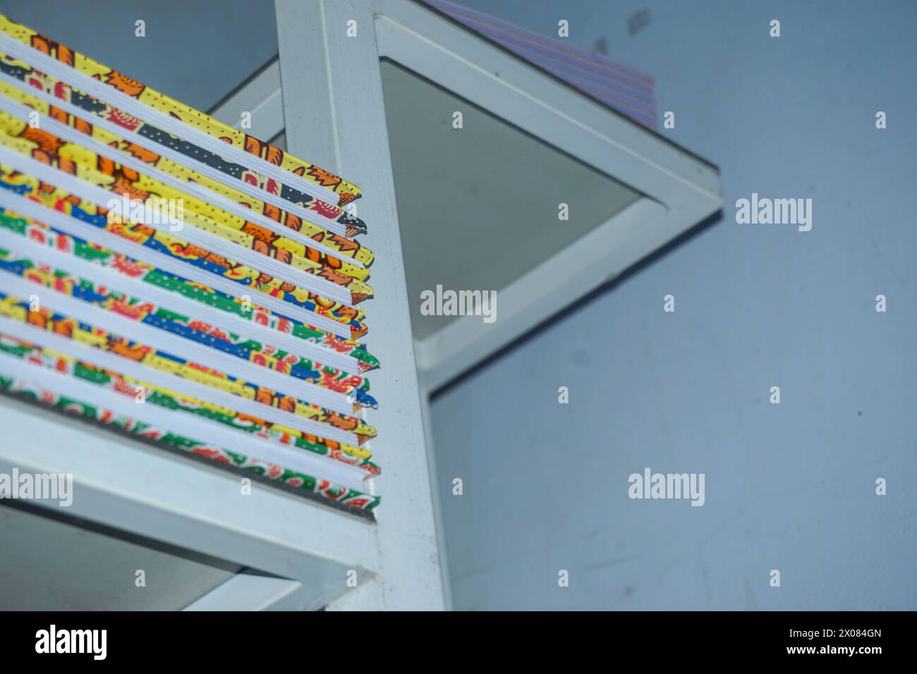 Photo of several books being opened and stacked on a reading shelf ...