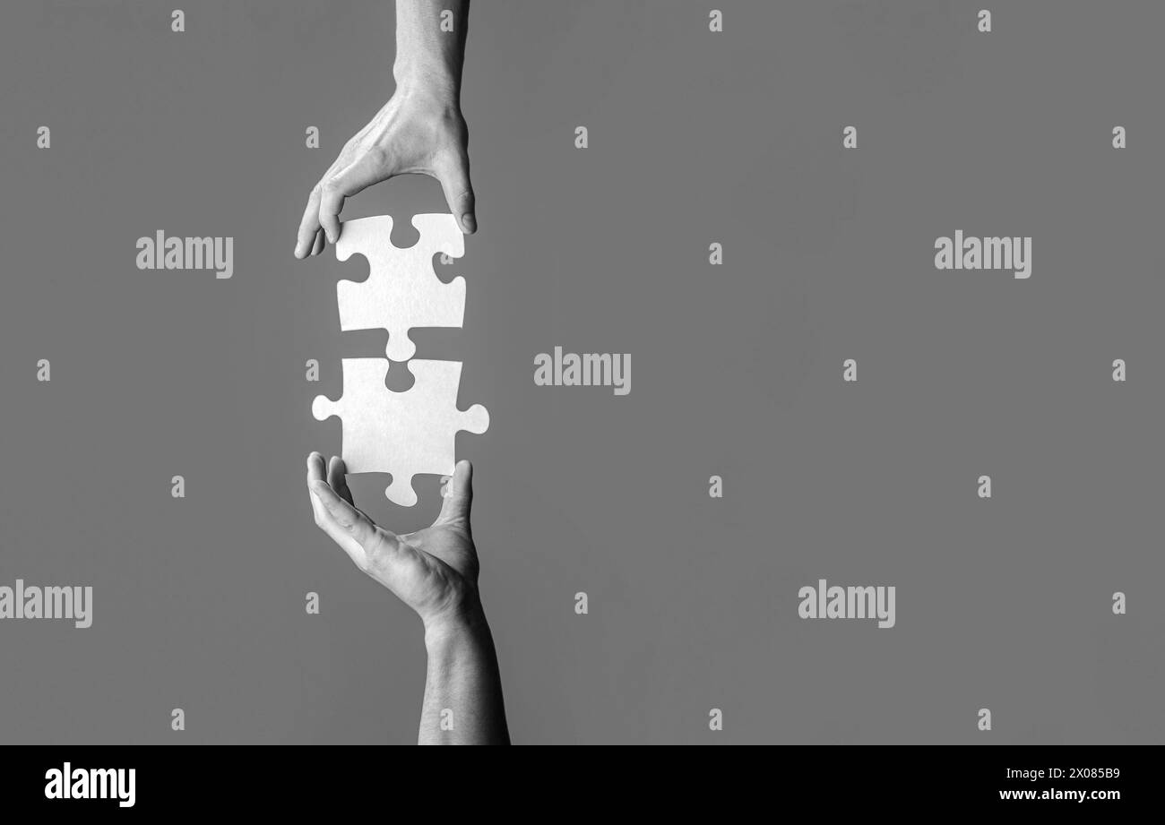 Closeup hands of man connecting jigsaw puzzle. Two hands trying to ...