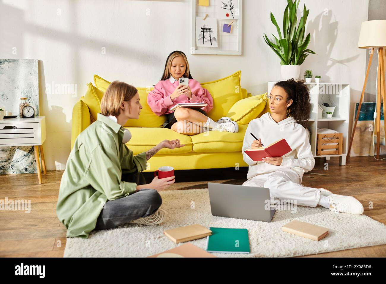 A diverse group of teenage girls study and bond on a cozy yellow couch ...
