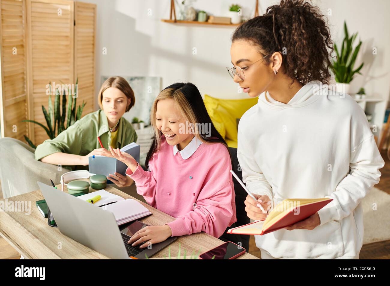 A group of interracial teenage girls engage in collaborative studying ...