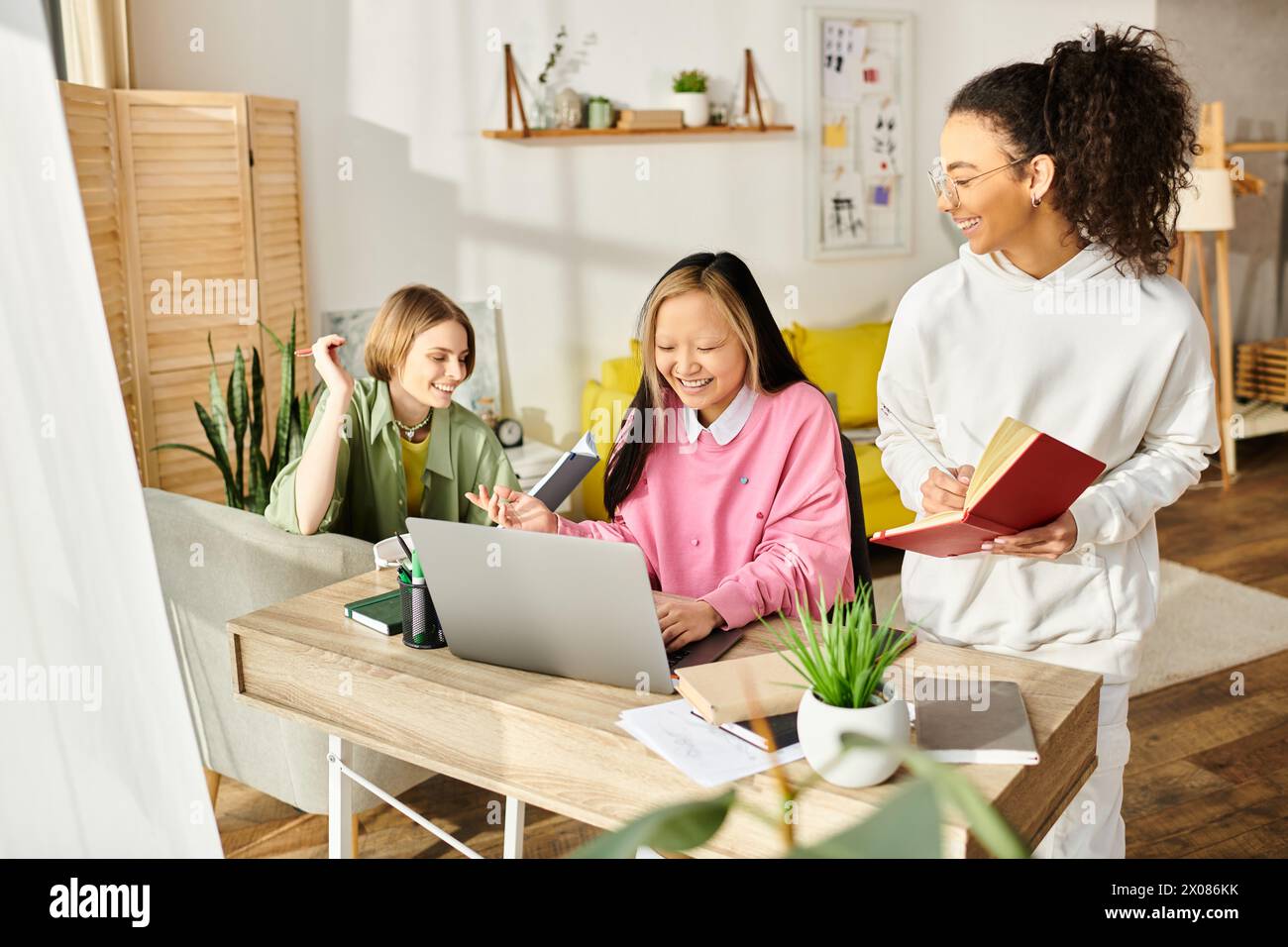 A woman and two girls engage in virtual learning, gazing at the laptop ...