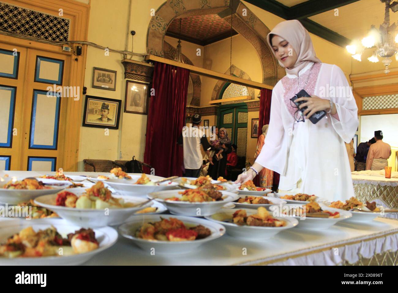 A Muslim woman serves vegetable lontong, a typical Eid al-Fitr dish ...