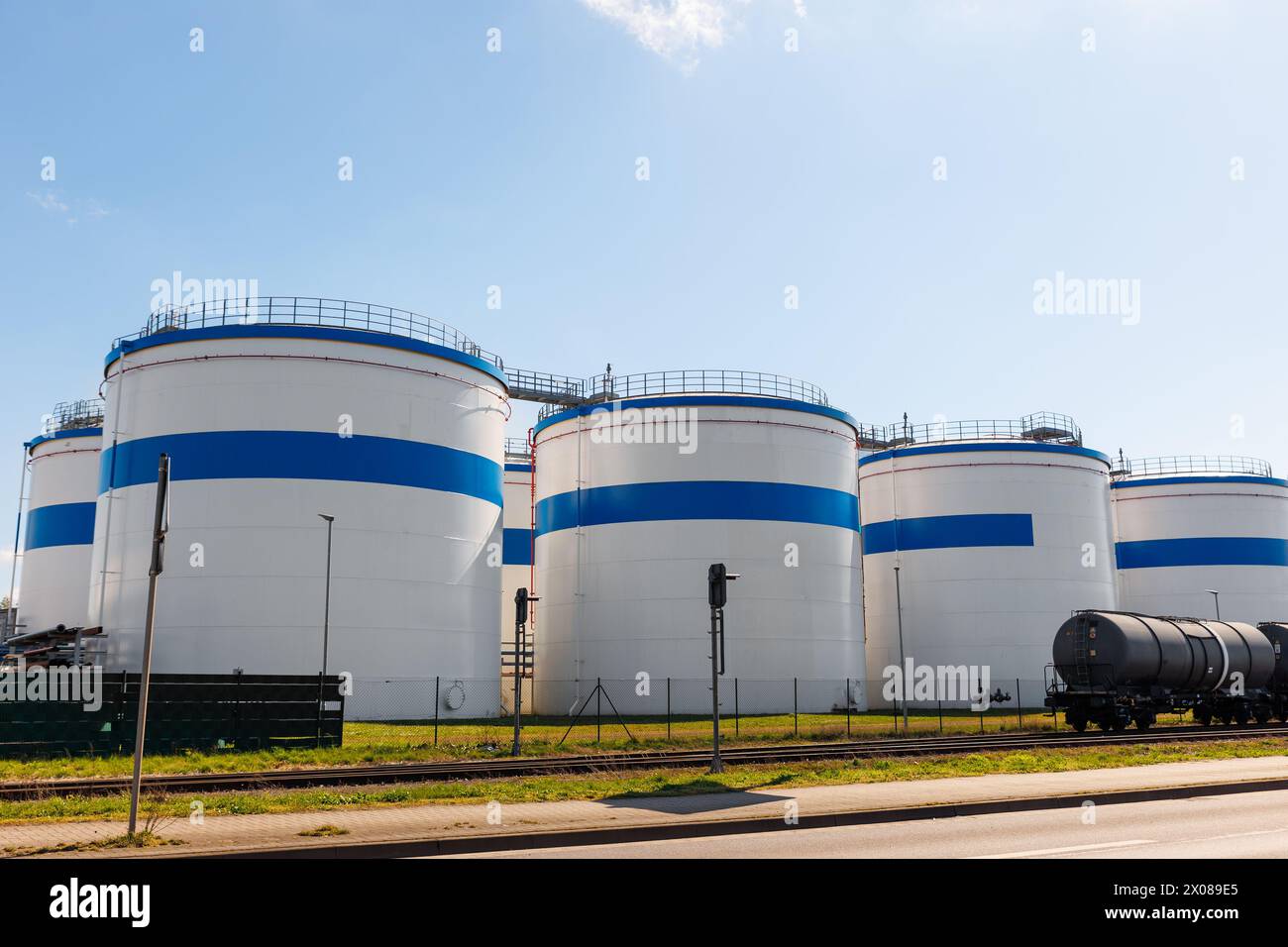Row many large industrial fuel storage white tanks clear blue sky ...