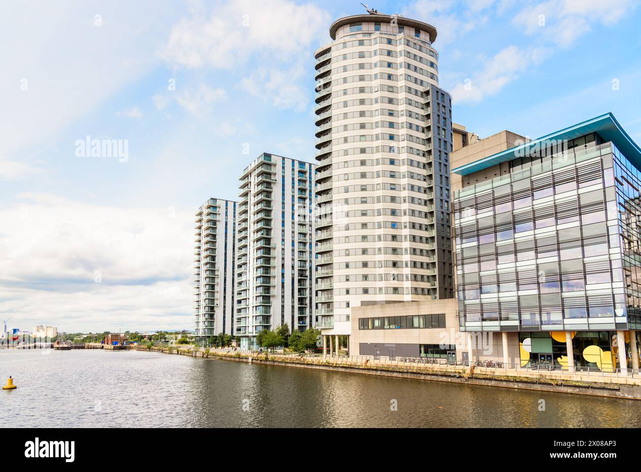 Modern residential towers and a glass office building in a quayside ...