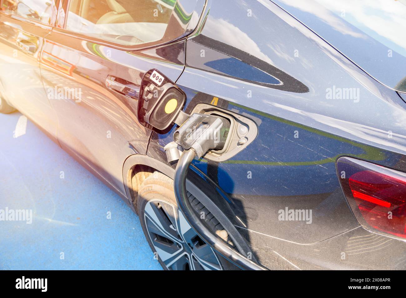 Close up of the power supply plugged into an electric car being charged ...