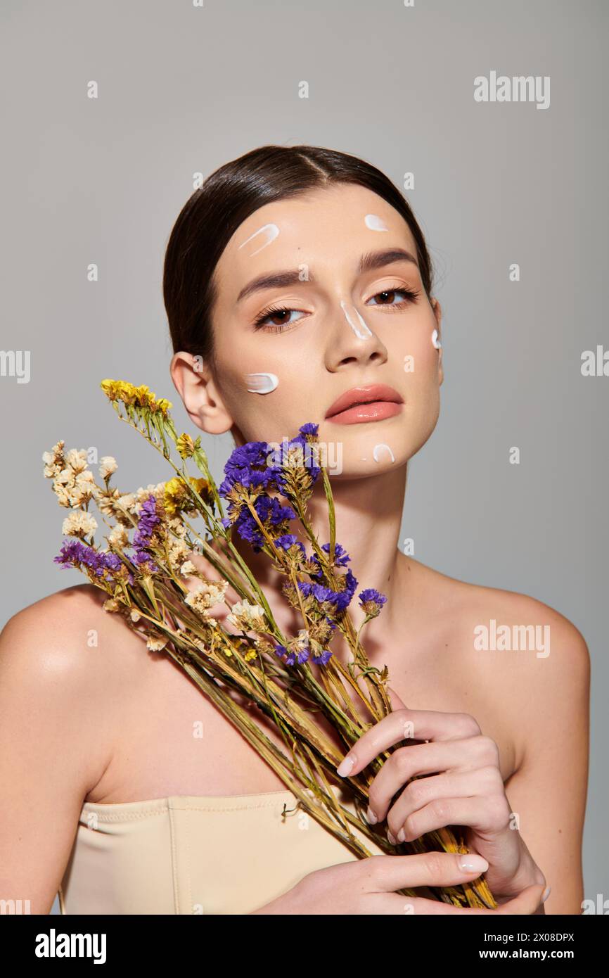 A brunette woman joyfully holds a bunch of flowers as bubbles float ...