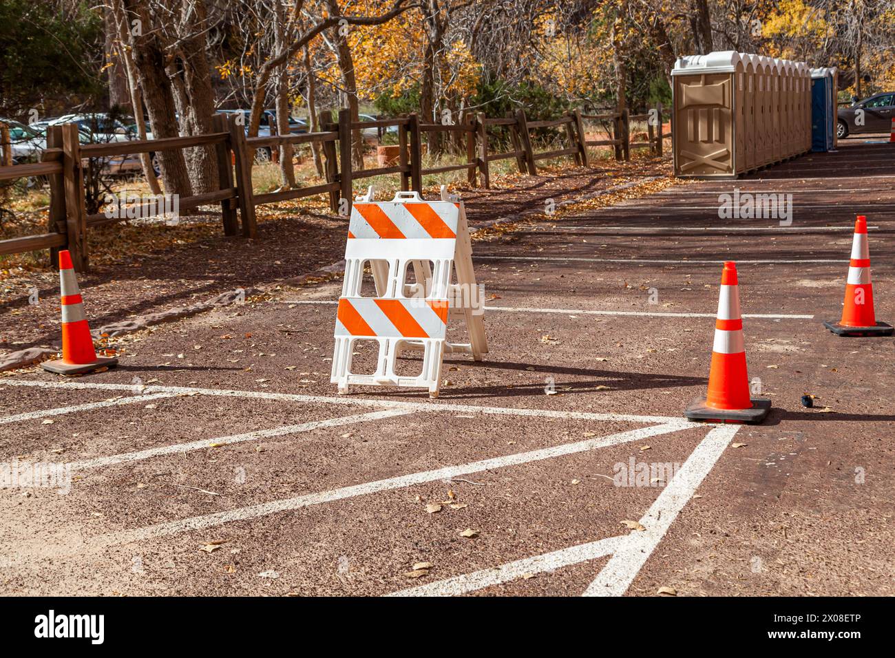 Safety cones and a barricade block off parking areas near portable ...