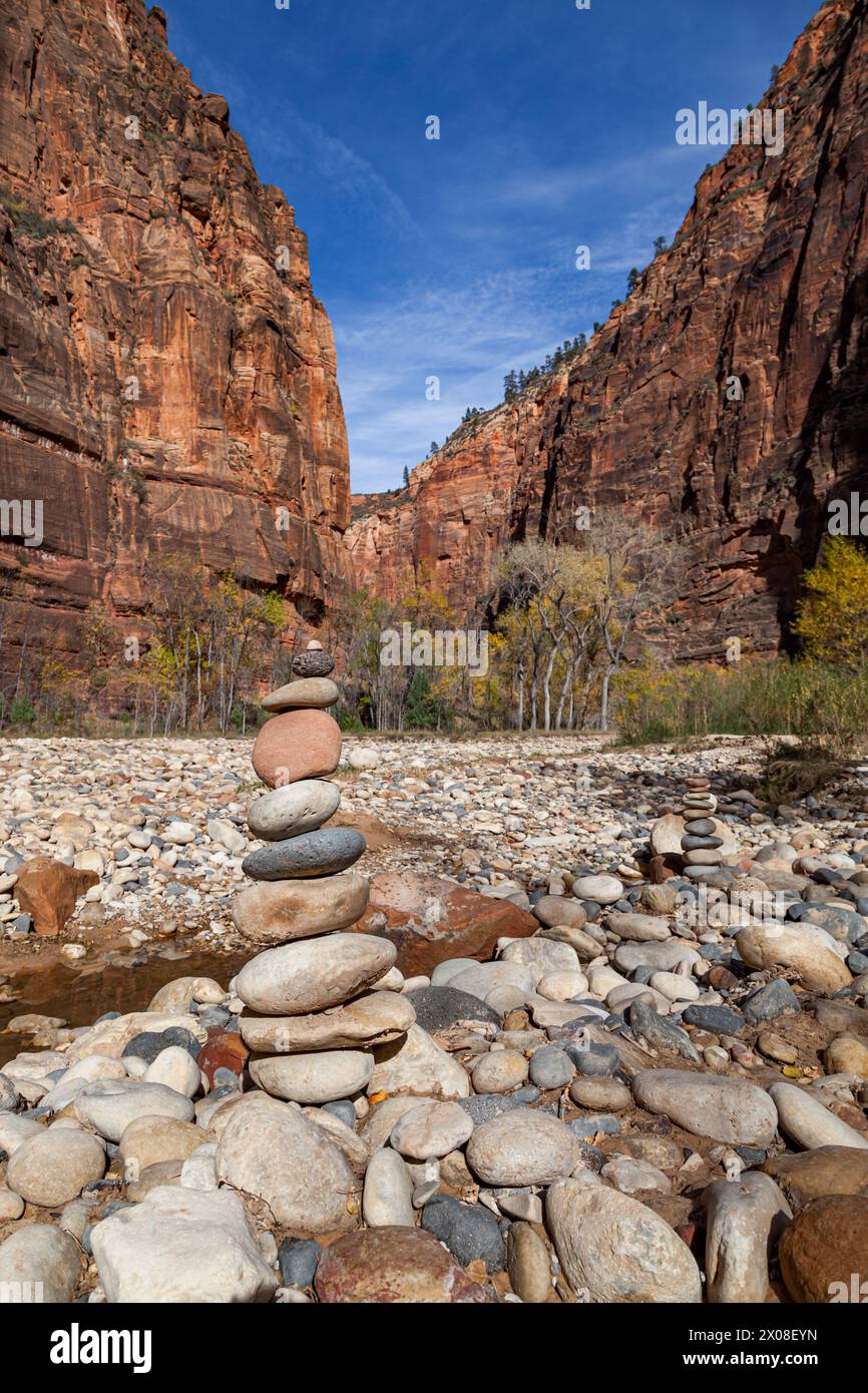 A well balanced stack of rocks in a variety of sizes and shapes next to ...