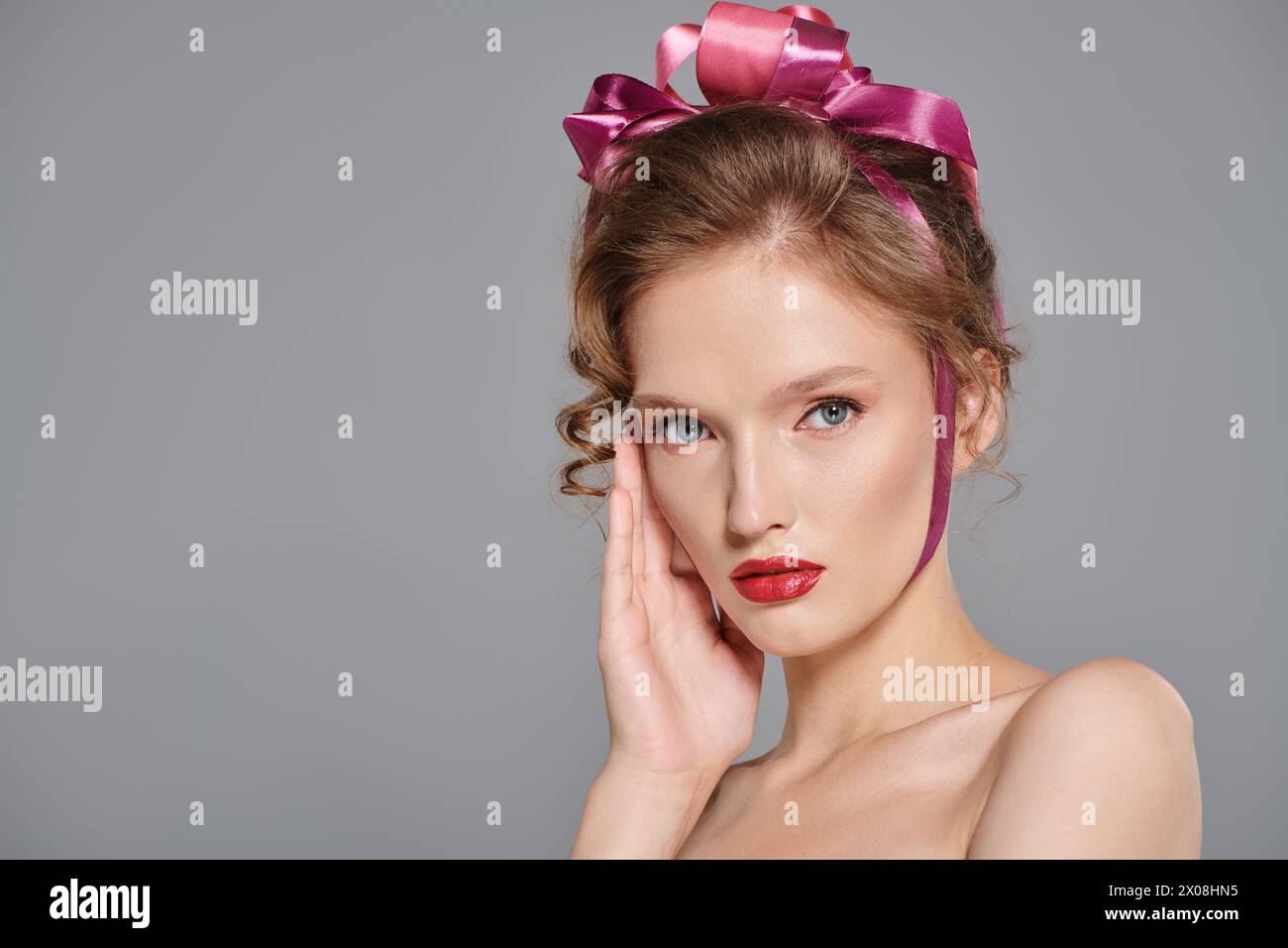 A young woman exudes classic beauty while posing in a studio, wearing a ...
