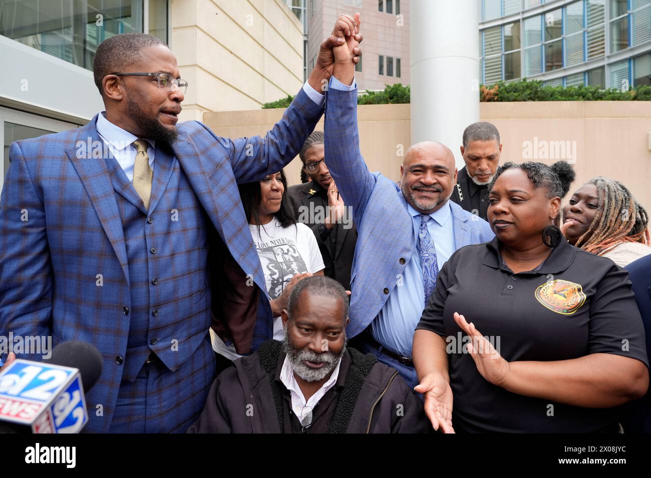 FILE - Civil lead counsel Malik Shabazz, left, raises the hand of co-counsel Trent Walker as ...