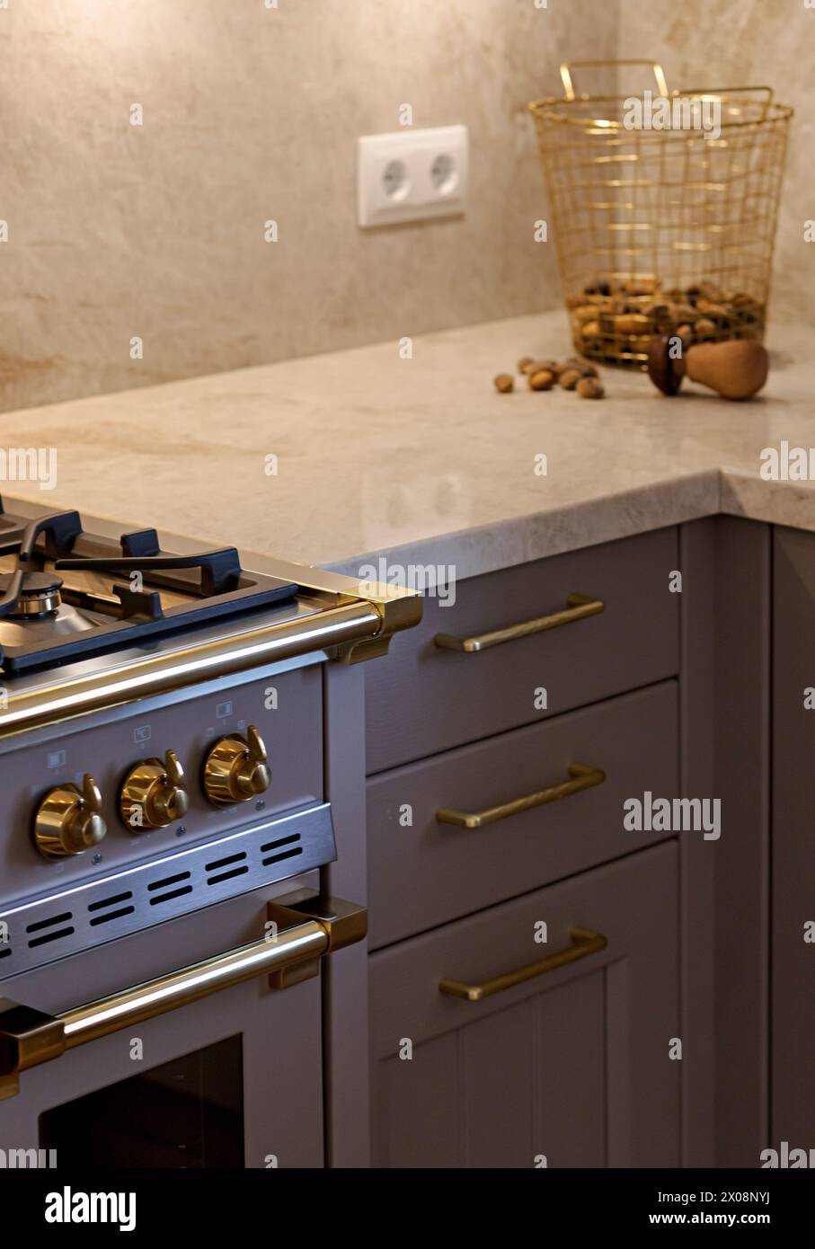 A contemporary kitchen featuring a stylish gas stove with golden knobs ...