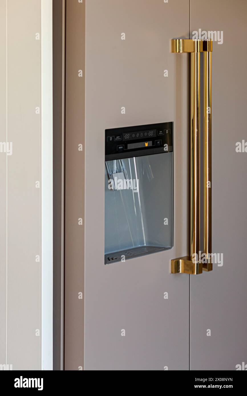 Modern built-in wall oven with a sleek black finish and golden handle ...