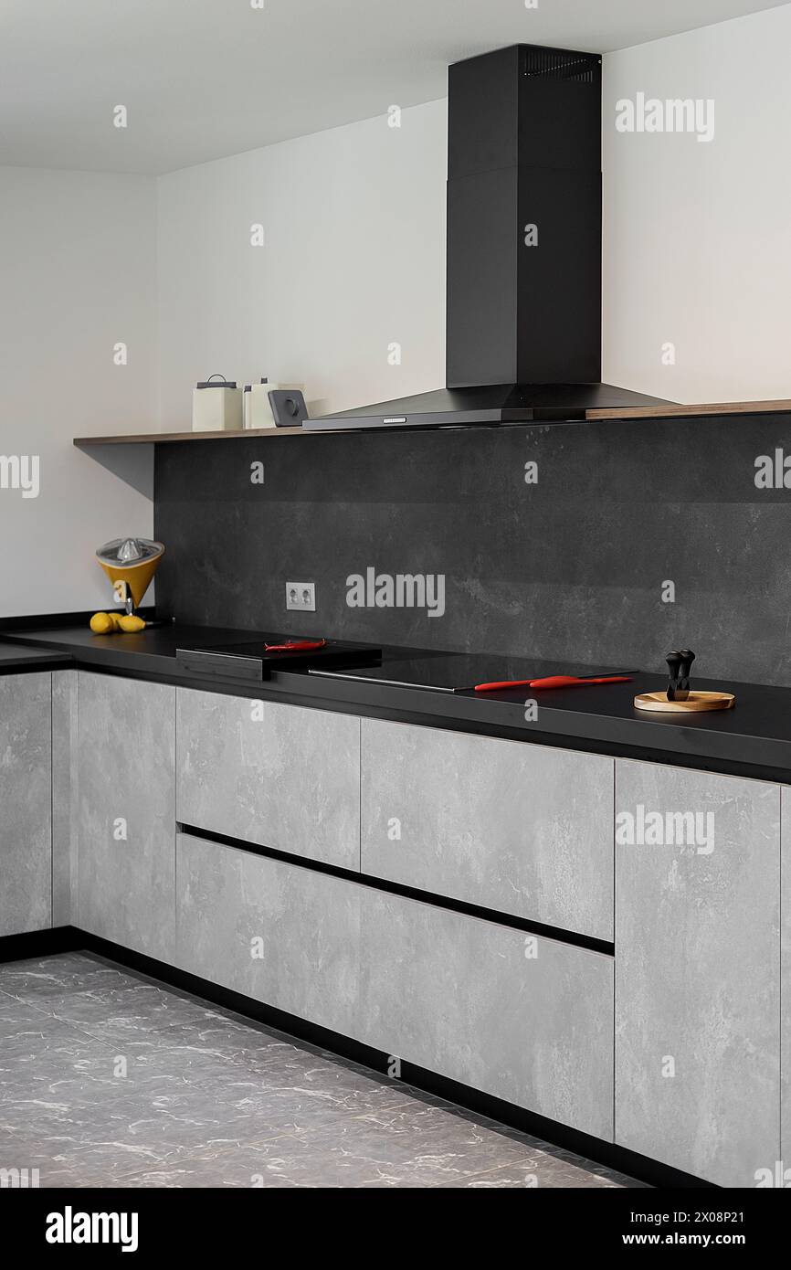 Sleek and stylish modern kitchen with dark stone countertops and gray ...