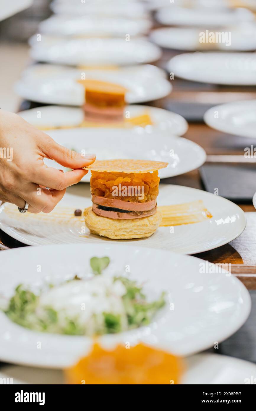 Anonymous chef hands artfully assemble a layered appetizer, carefully ...