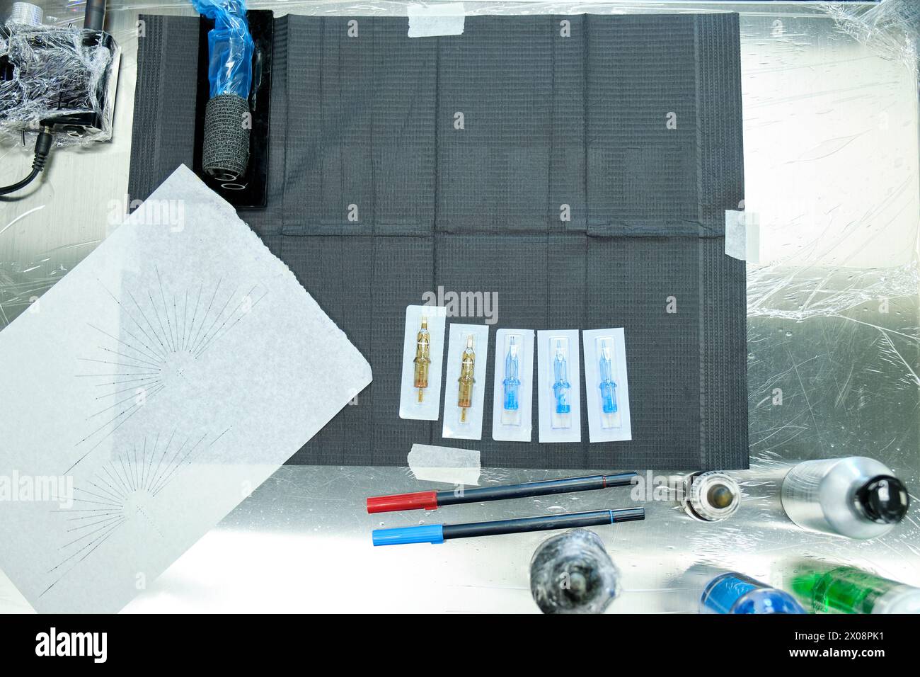 A top view of a tattoo artist's workspace, showcasing arranged needles ...