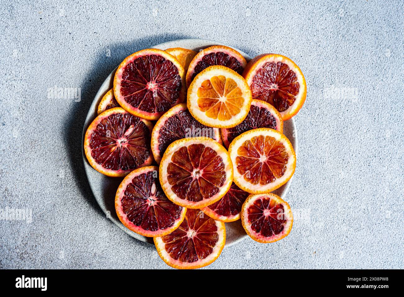 Top view of vibrant Sicilian blood orange slices arranged on a circular ...