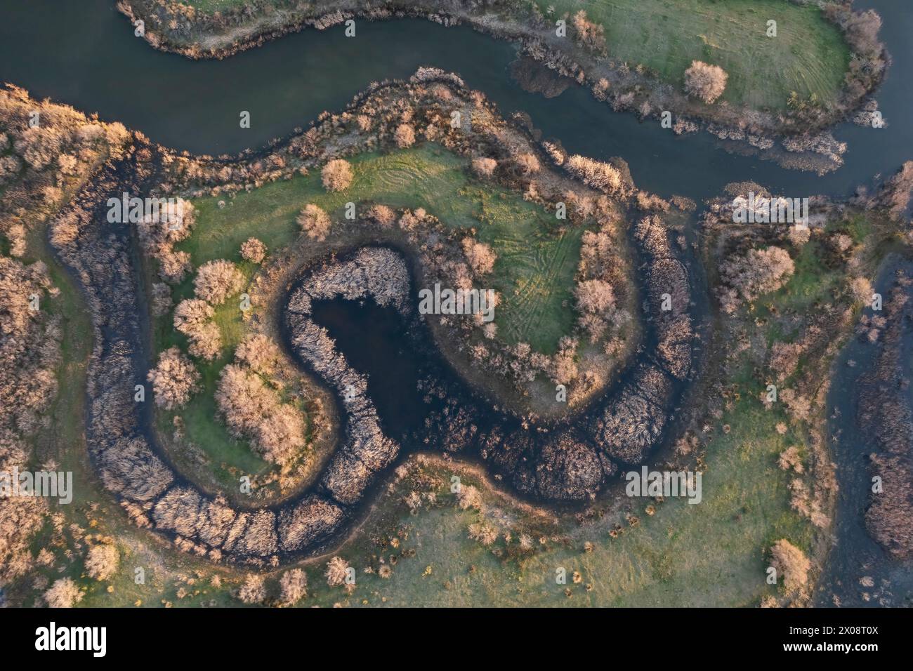 Aerial shot of the winding Ciguera River cutting through the landscape ...