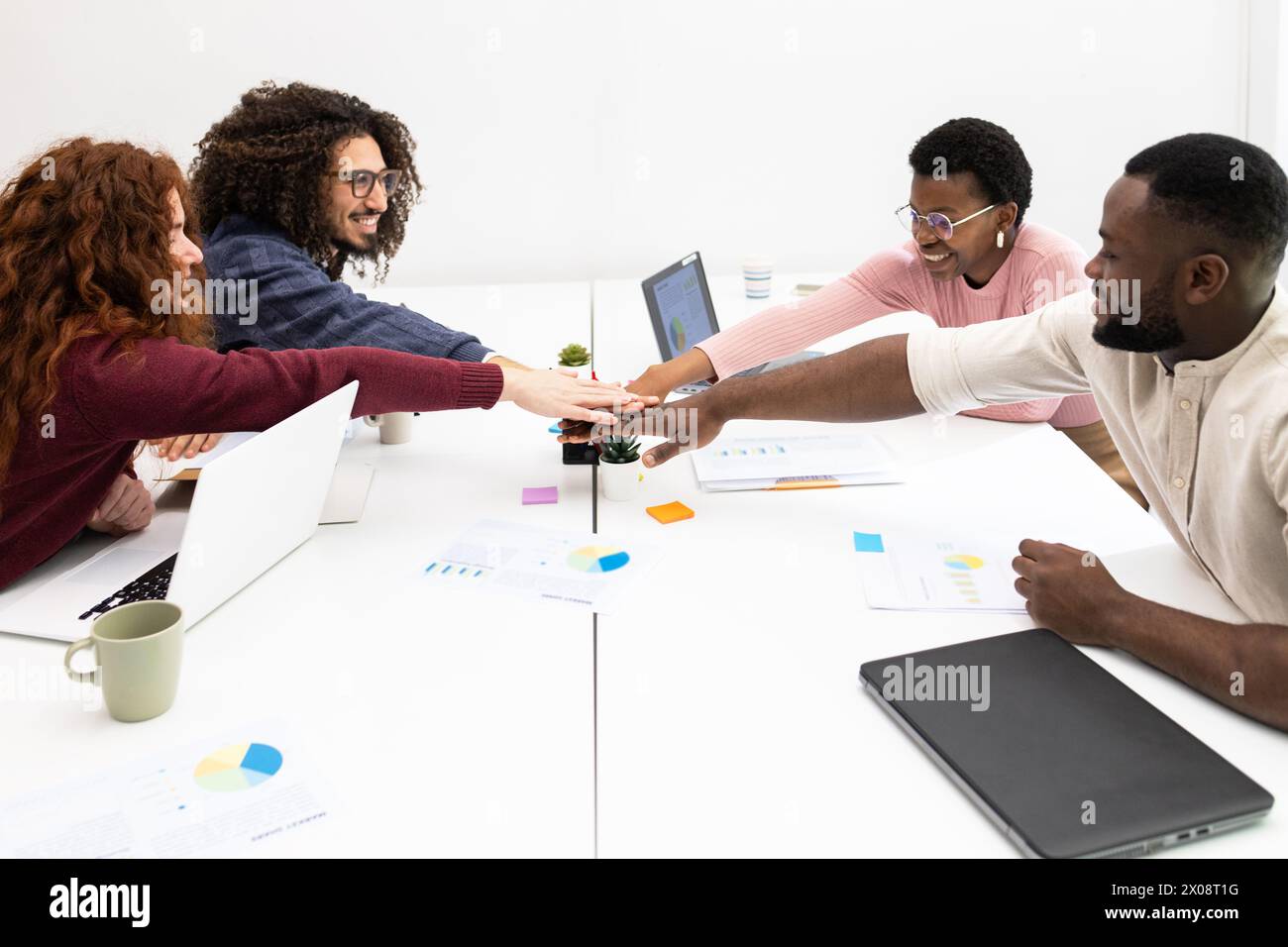 Diverse team of professionals celebrating success with a fist bump over ...