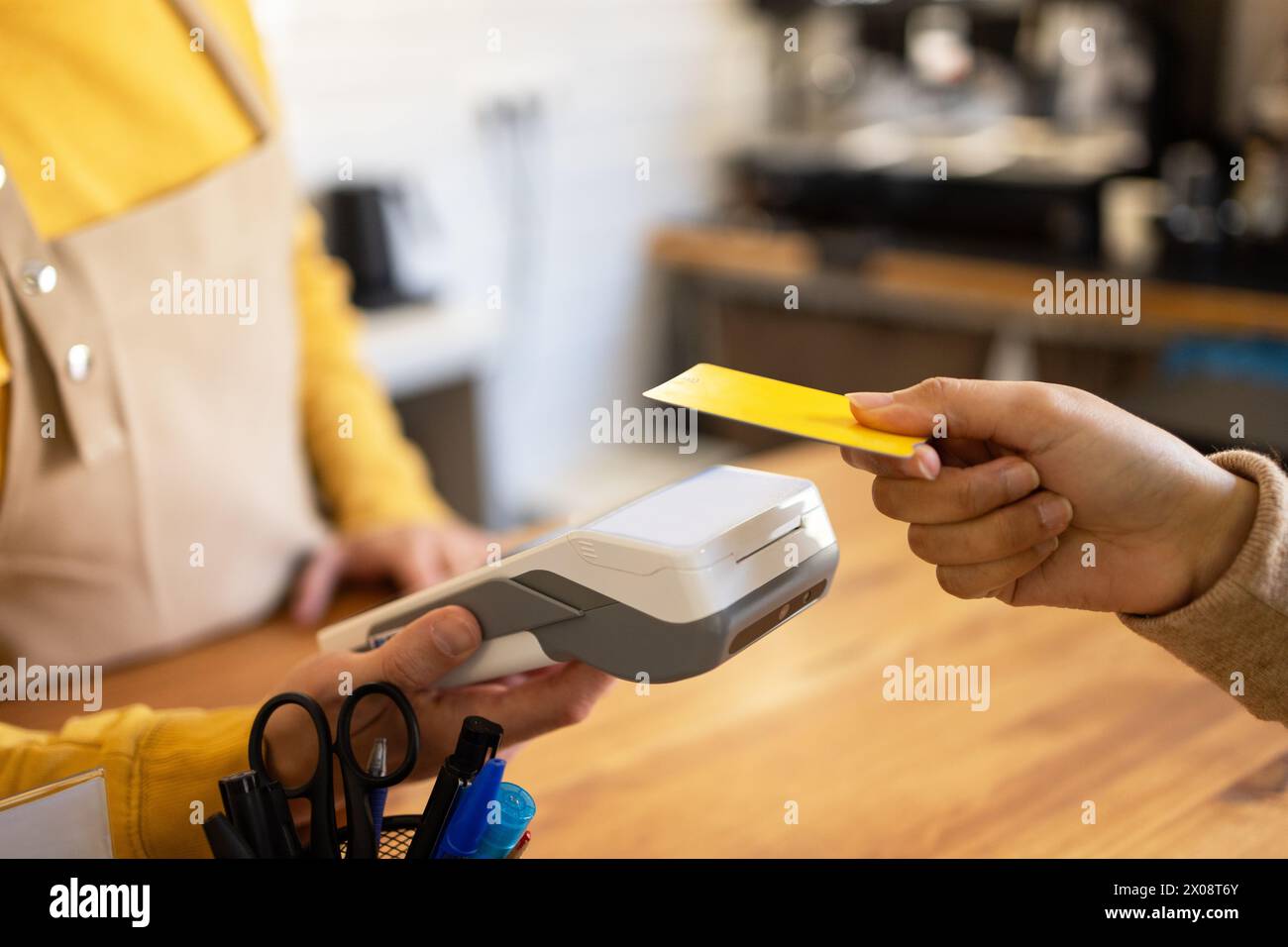 A customer makes a contactless card payment at a cafe's point of sale ...