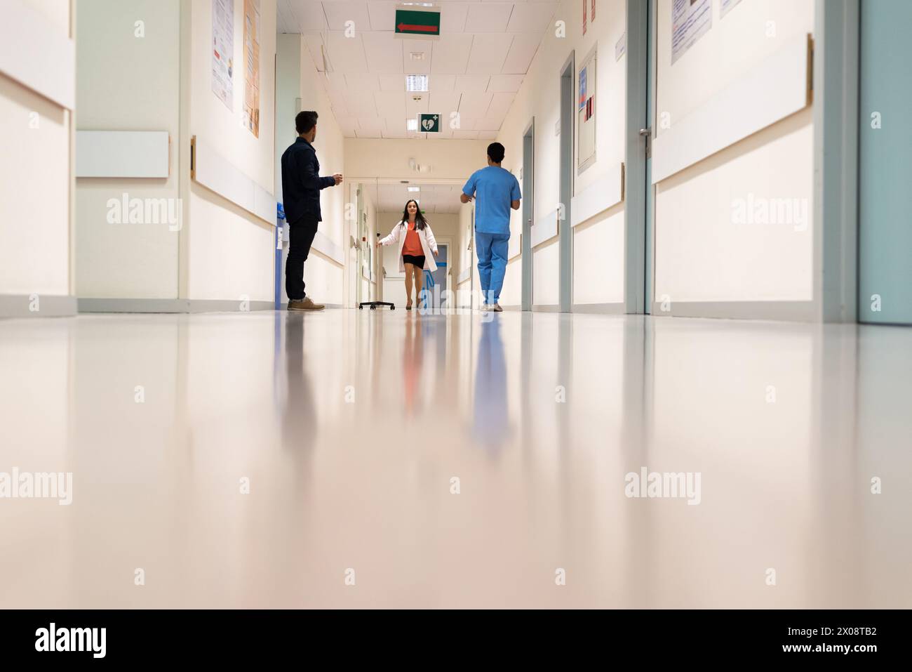 Female medic running in hall of hospital beneath people Stock Photo - Alamy