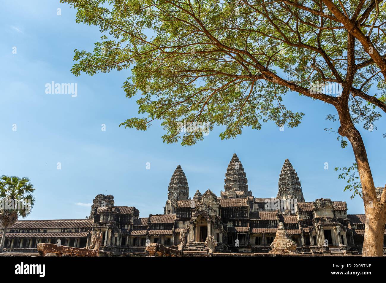 The iconic towers of Angkor Wat Hindu temple rise against a clear blue ...