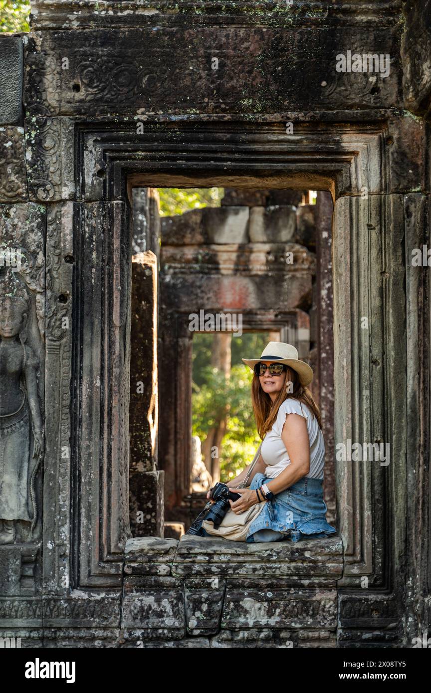 A female tourist in a white hat is photographed among the ancient stone ...