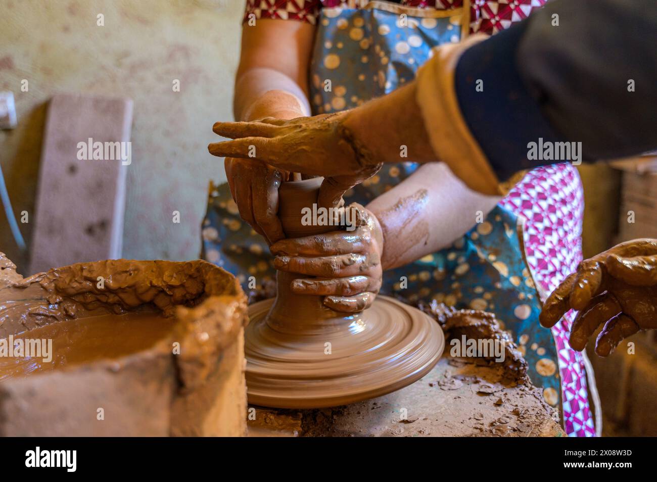Close-up of a cropped unrecognizable artisan's hands skillfully molding ...