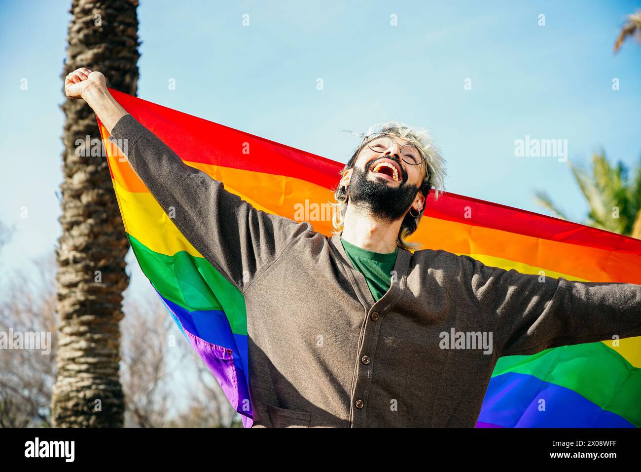 An exuberant individual celebrating, arms raised high with a vibrant ...