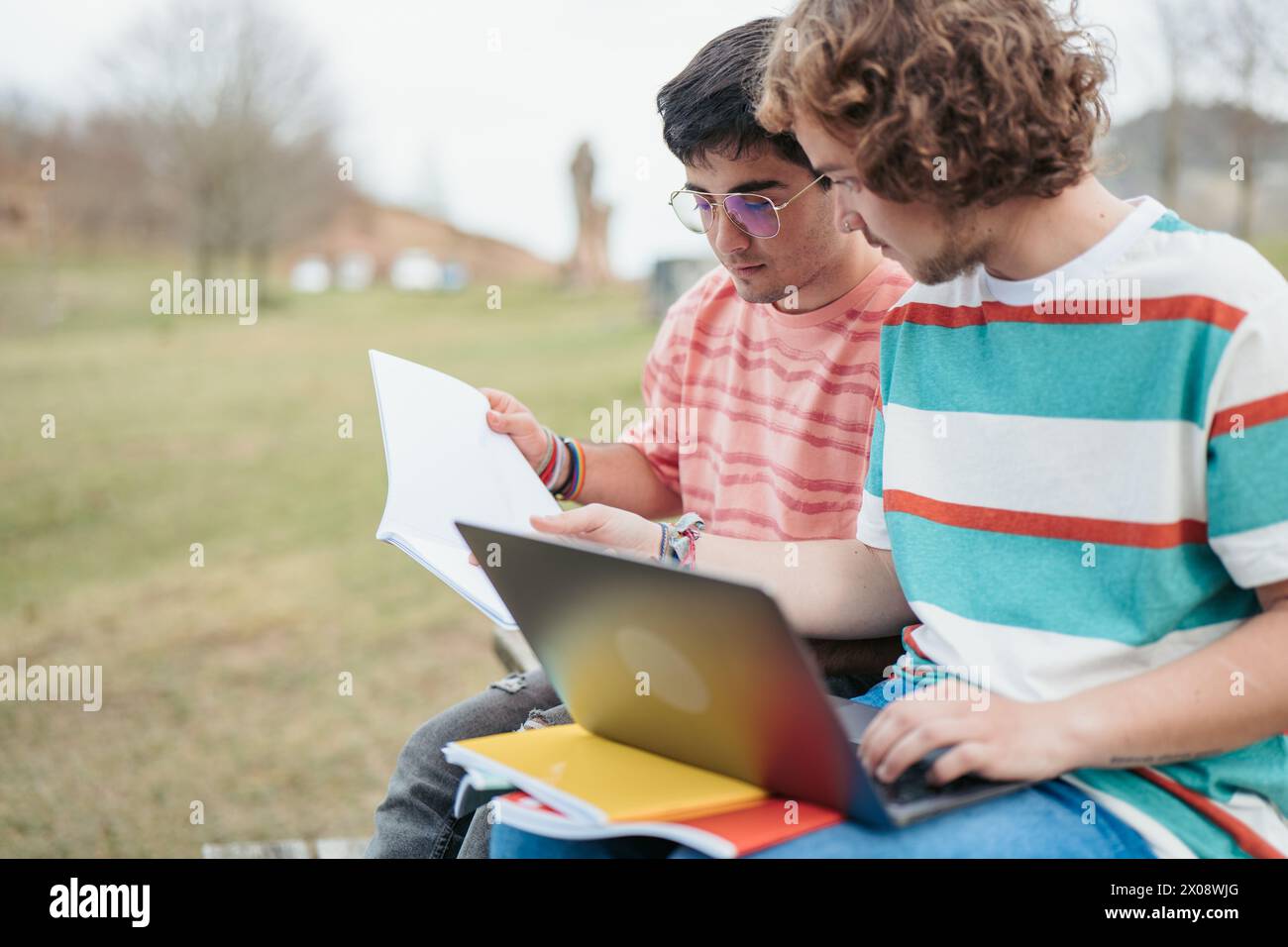 A dedicated gay couple, both transgender, collaboratively studying from ...