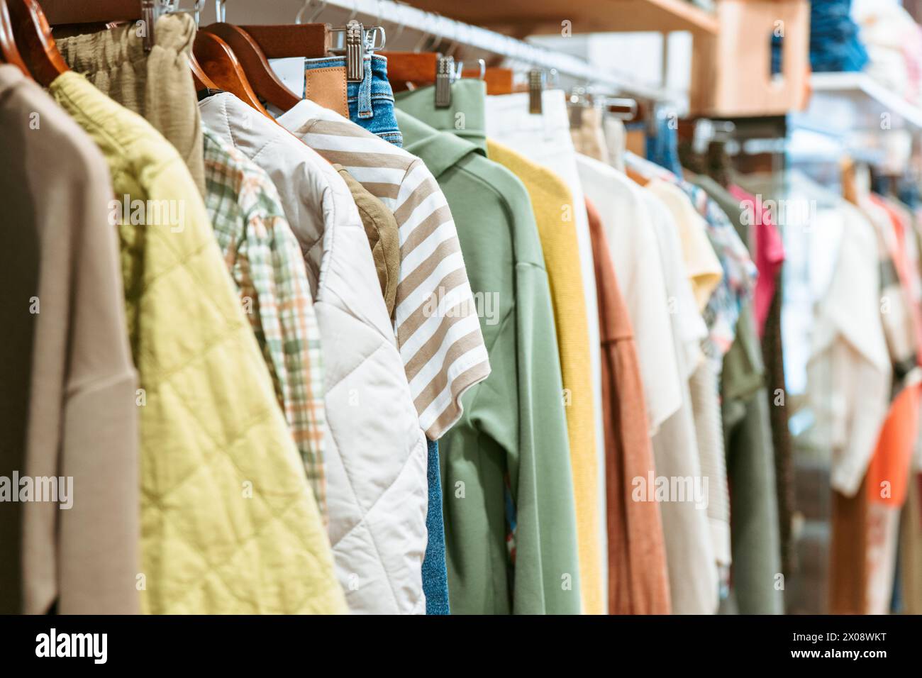 A diverse collection of casual garments hangs neatly on a rack in a ...