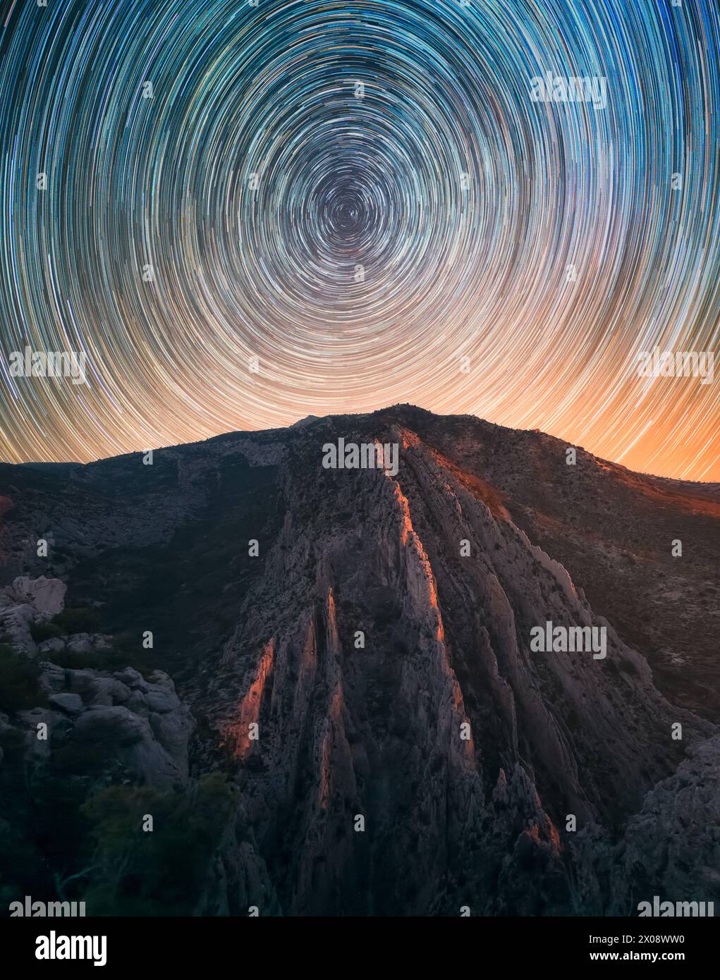 Star trails spiral in the night sky, creating a hypnotic pattern over a ...