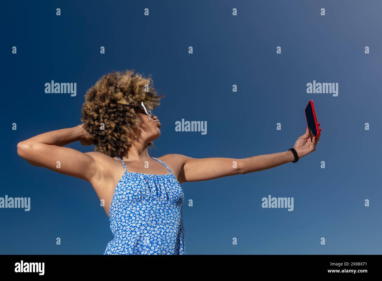 From below of black woman captures a selfie moment with a smartphone on ...