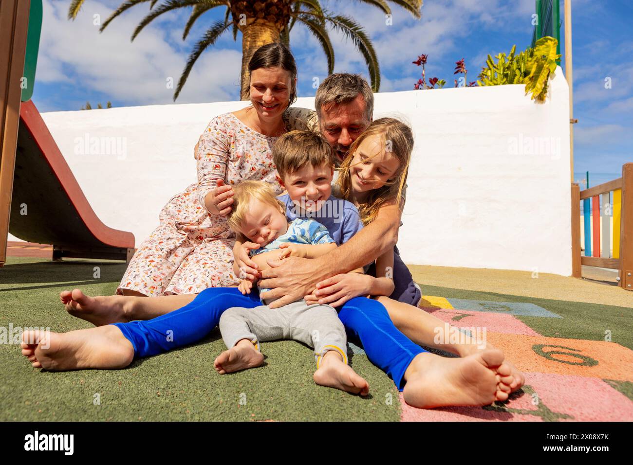 A happy family enjoys a playful moment together at an outdoor ...