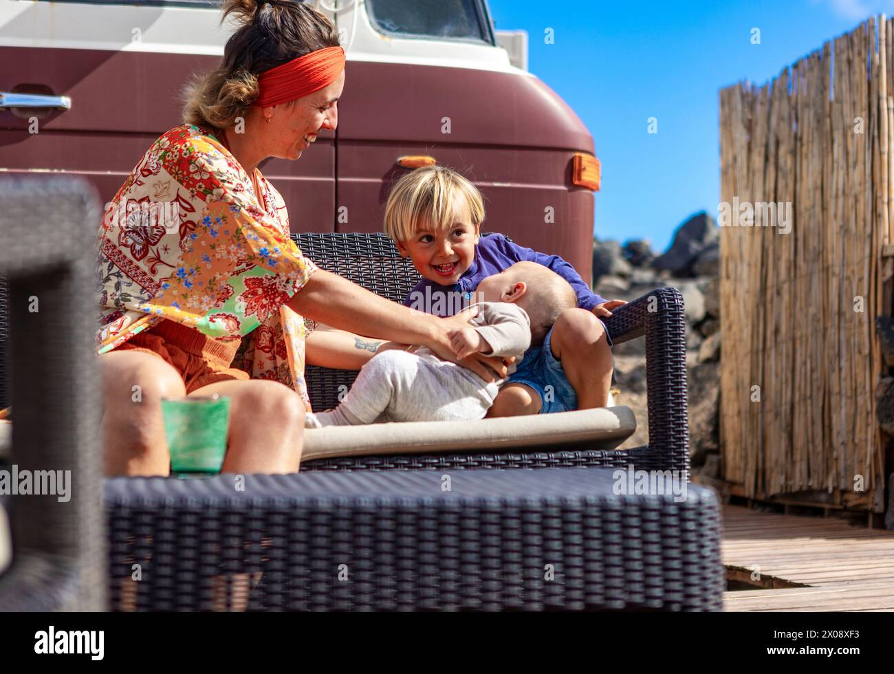 A mother interacts with her children outside a van, creating a cozy ...