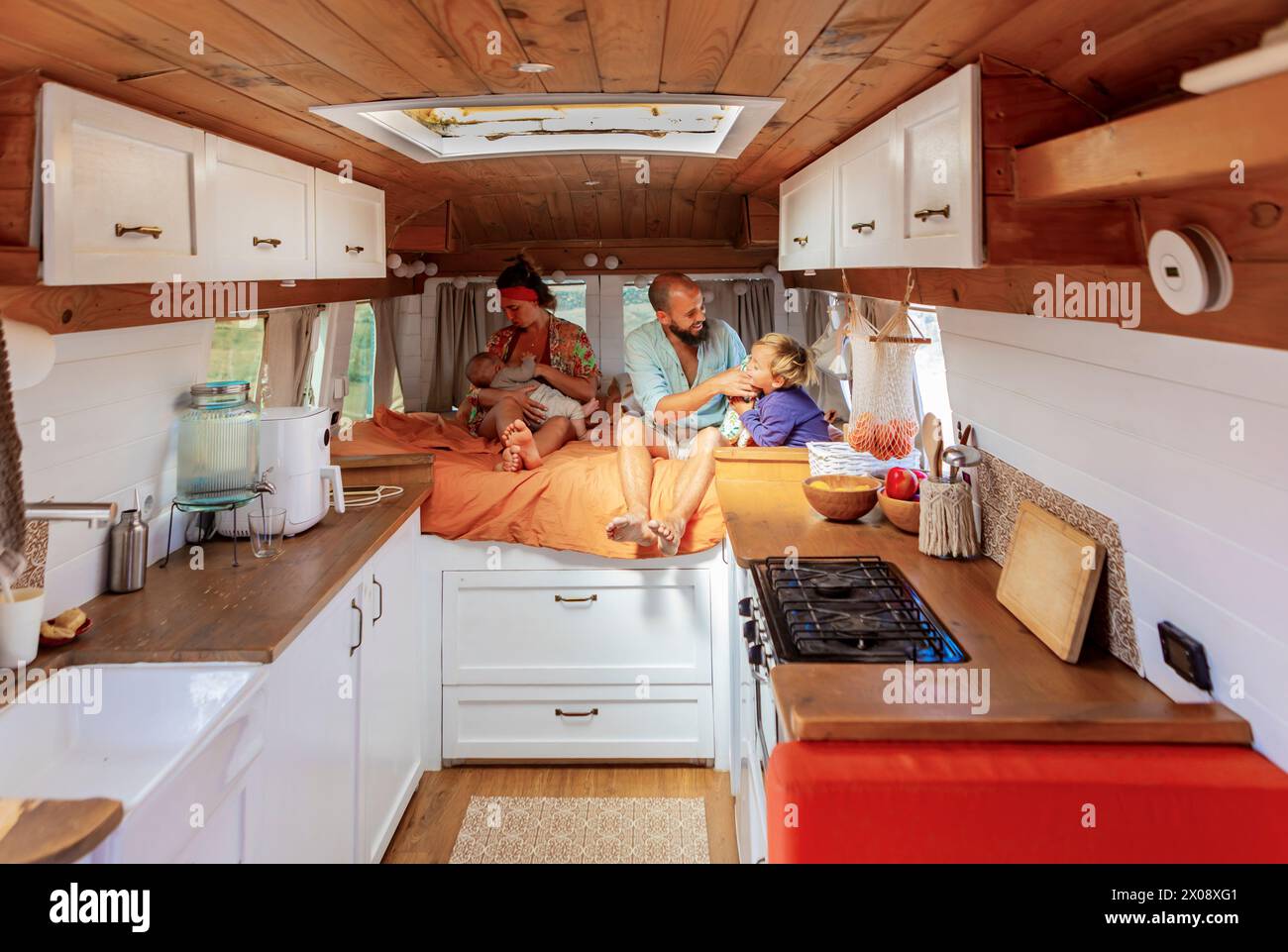 A family embraces van life, with a mother breastfeeding, a father ...
