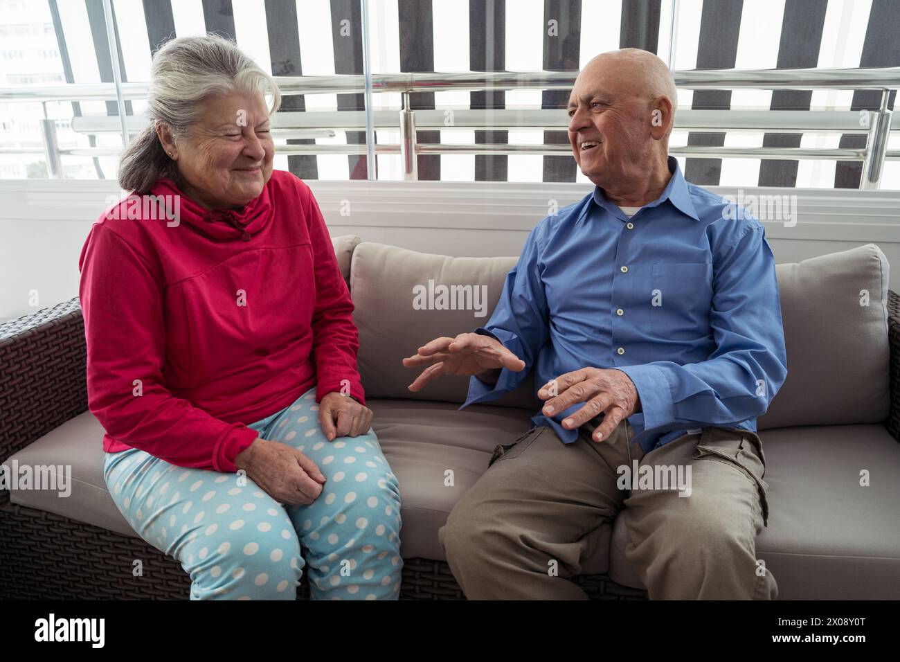 Two senior adults smiling and engaging in a pleasant conversation on a ...