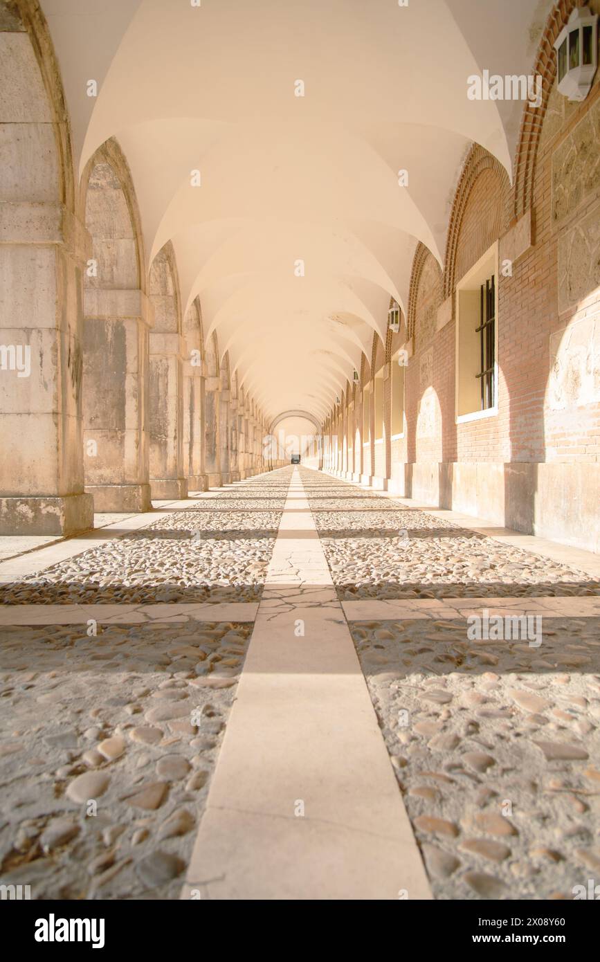 A perspective view of the sunlit arches of the Royal Palace of Aranjuez ...