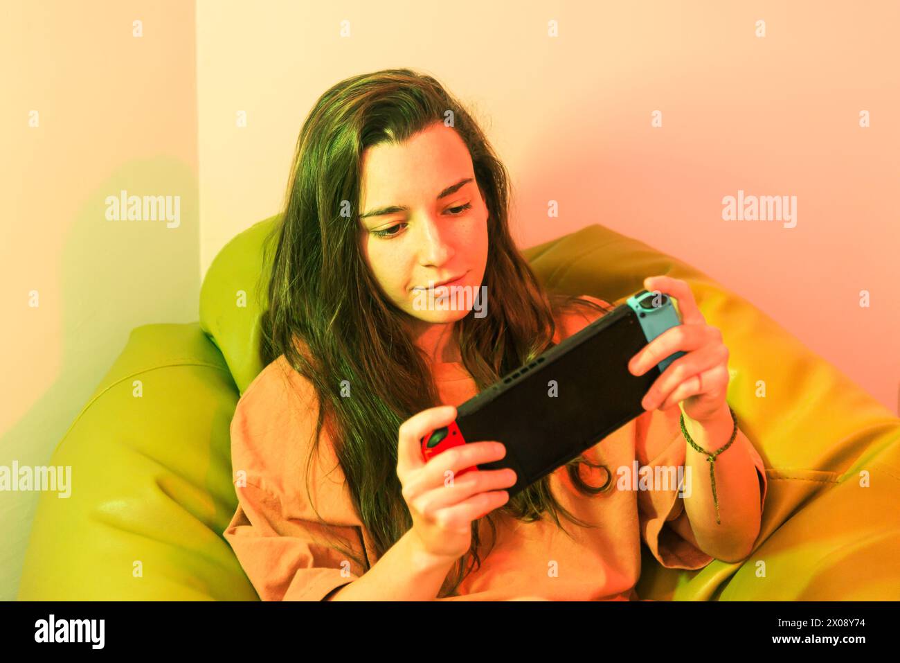 A relaxed gamer is captured in a moment of focus while playing on a ...